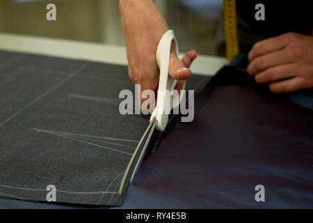 Master cuts fabric. Nesting. Suiting fabric marked with white chalk ...