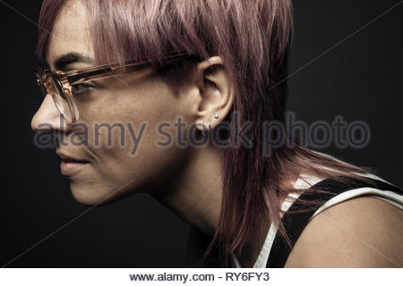 Close up portrait of non-binary trans woman standing hear the window at ...