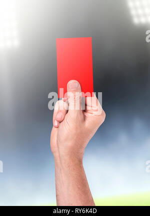 A male sports referee or umpire hand holding a red card up in the air ...