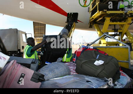 Baggage handlers unloading luggage from an airplane at Dusseldorf ...