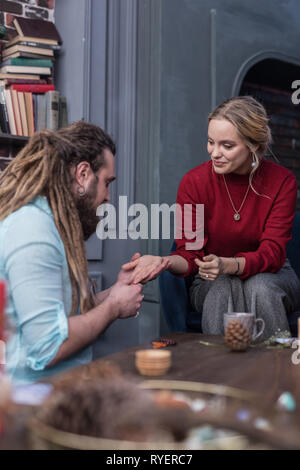 Young woman at fortune teller chiromancer consultation side view shot ...