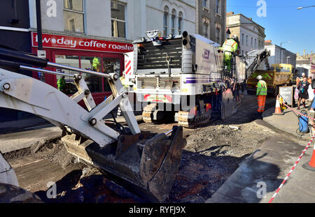 Road resurfacing works, removing old tarmac road surface with road ...