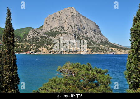Ukraine, Crimea, Novyi Svit. View of Novyi Svit bay town with giant ...