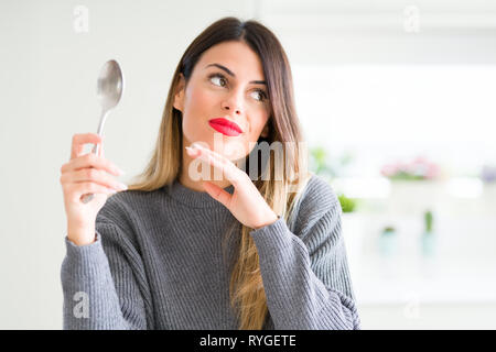 Confused beautiful silver girl showing and holding copyspace isolated ...