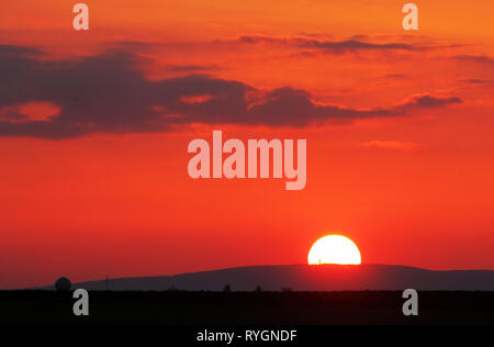 Beautiful red and orange sunset over the sea in a cloudy sky. The sun ...