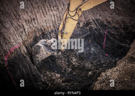 Excavator digging soil inside construction site Stock Photo - Alamy