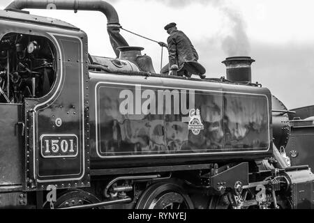 Man filling up steam engine locomotive train with water in summer ...