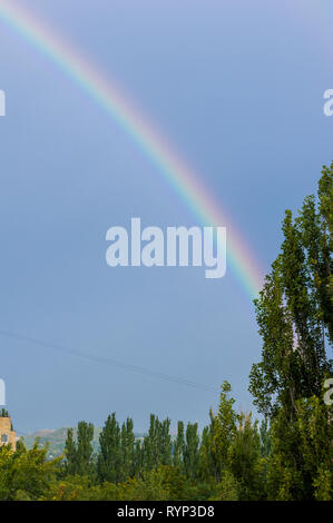 Natural double rainbow over green trees, city landscape Stock Photo - Alamy