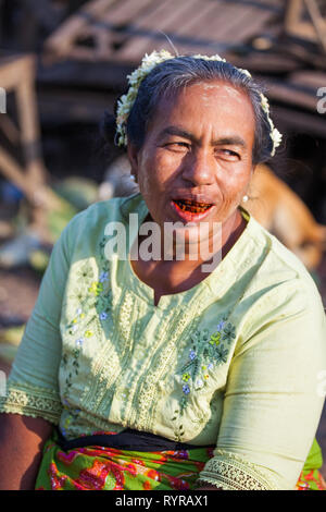 Woman with red teeth from chewing the betel nut at the market of Goroka ...