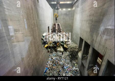 Gripper arm over pile of trash, crane transports waste in a waste ...