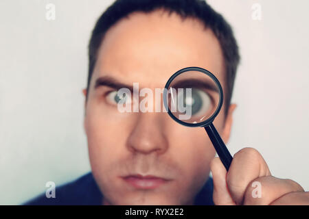 Detective looks evidence through magnifying glass Stock Photo - Alamy