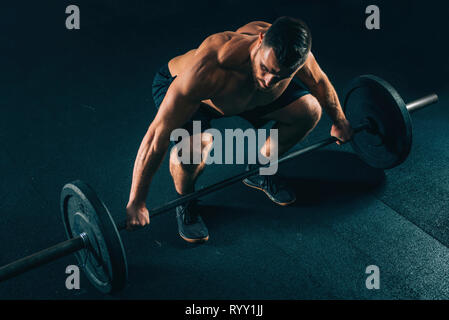 Black man lifting weights in warehouse Stock Photo - Alamy