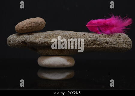 feather red and stone balance Stock Photo - Alamy