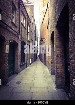 Narrow passage between two buildings leading to the sunny street Stock ...