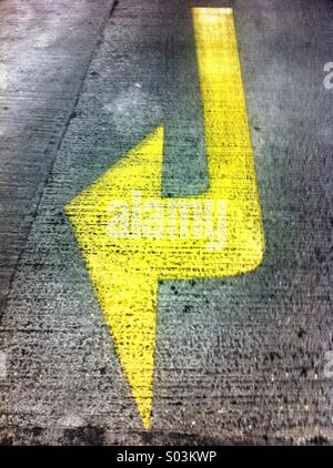A bright yellow directions sign with an arrow and clear symbols ...