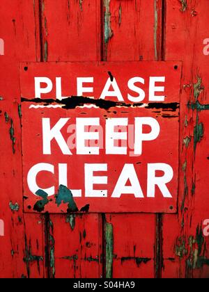 Please keep gate clear sign in metal gate fence Stock Photo - Alamy