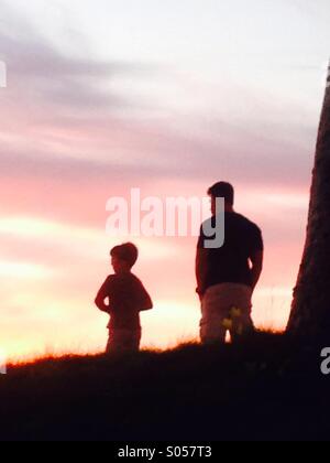Father and son looking at sunset Stock Photo - Alamy
