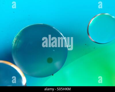 Oil floating on water surface in a glass Stock Photo - Alamy