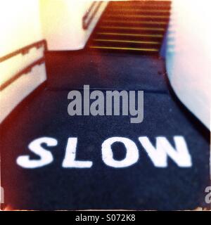 Slow Down Bicycle sign painted on concrete pavement on the Brisbane ...
