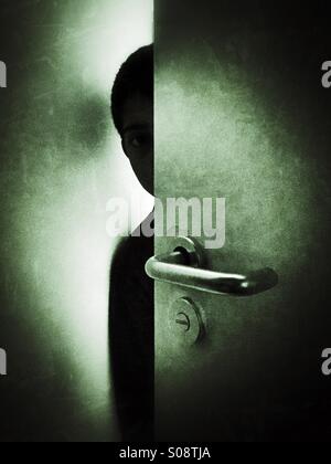The boy hide behind the door with fear and loneliness Stock Photo - Alamy