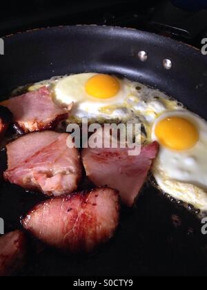 Cooking ham and eggs in a frying pan Stock Photo - Alamy
