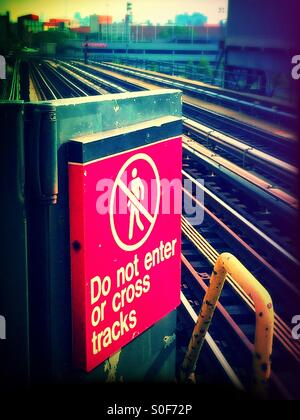 Do not enter or cross tracks sign and subway train Stock Photo - Alamy