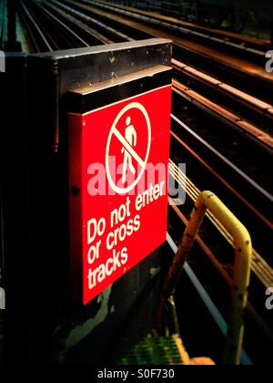 Do not enter or cross tracks sign and subway train Stock Photo - Alamy