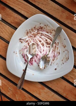 Empty plate and two dessert spoons after dessert is eaten Stock Photo ...