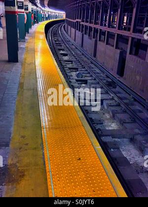 Subway platform yellow safety strip and tracks, New York City Stock ...