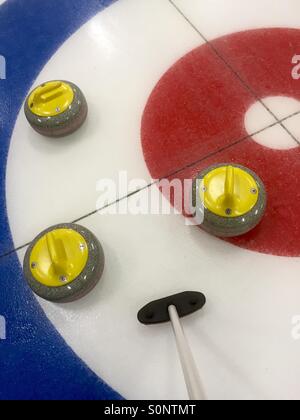Yellow and Red Curling stones on the ice Stock Photo - Alamy