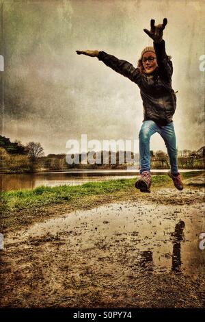 child girl jumping over puddle Stock Photo - Alamy