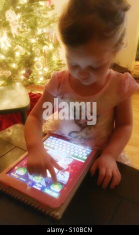 Little girl is using Apple iPad to draw and entertain herself at home ...