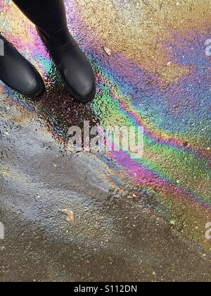 Rain boots on oil spill Stock Photo - Alamy