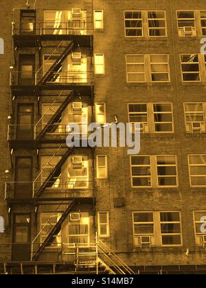 Old building with fire escape at night, toned in blue Stock Photo - Alamy