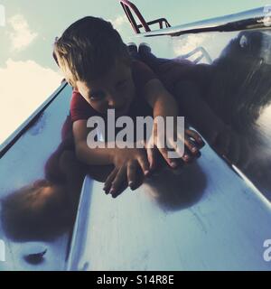 A young boy slides head first down a garden slide Stock Photo - Alamy