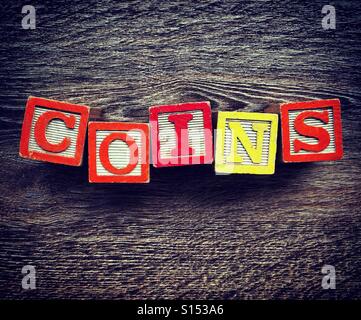 Word coins written with wooden letters on rustic surface Stock Photo ...