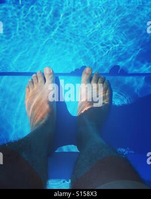 Pair of feet in swimming pool Stock Photo - Alamy