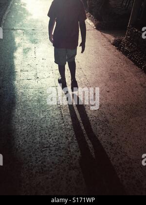 Back view of a shadowy male walking out of a dark room Stock Photo - Alamy
