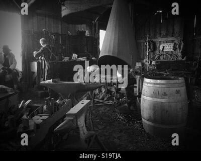 Blacksmith working in shop on main street in historic old gold rush ...