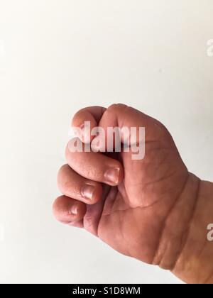 Little baby hand clenched into fist. Tiny new born baby's arm closeup ...