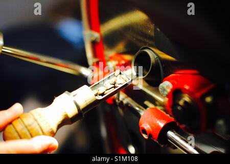 A coffee roaster checks coffee beans during roasting Stock Photo - Alamy