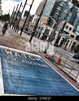 A blue and white sign with a bicycle image against a cloudy sky ...