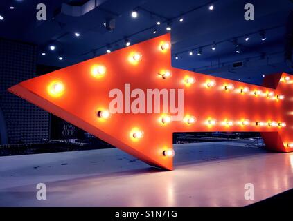 Metal arrow with lights pointing to the left Stock Photo - Alamy