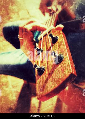 Woman playing a ukulele, high angle side view Stock Photo - Alamy