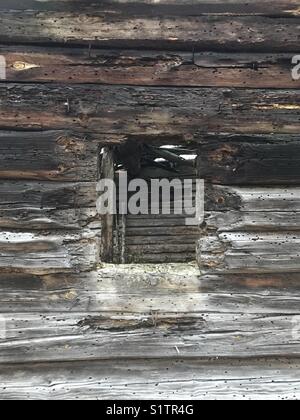 Old abandoned log house in the country surrounded by trees and farmland ...