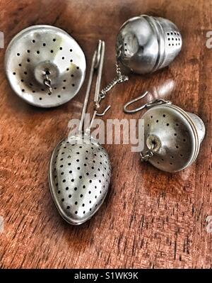 Vintage aluminum tea infusers arranged on awood table Stock Photo - Alamy