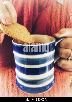 WOMAN DUNKING BISCUIT INTO TEA Stock Photo - Alamy
