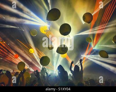 Partying crowd, stage lights and balloons at a live concert Stock Photo ...