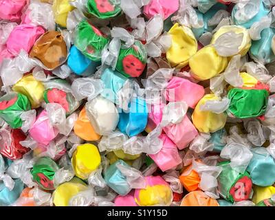 Frame of candies in colorful wrappers on light green background, flat ...