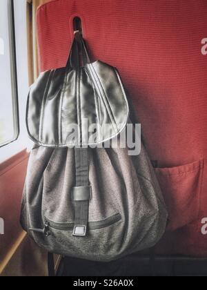 Backpack hanging by a window Stock Photo - Alamy